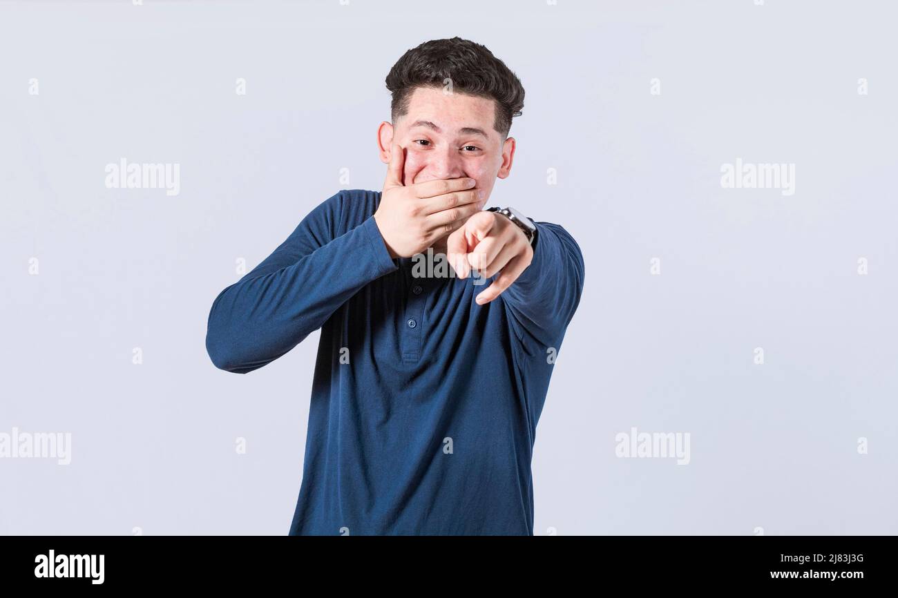 Isolated attractive guy laughing at you, A man pointing at camera with ...