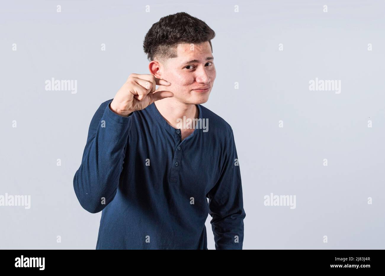 Man showing a small amount with his fingers, young man gesturing with ...