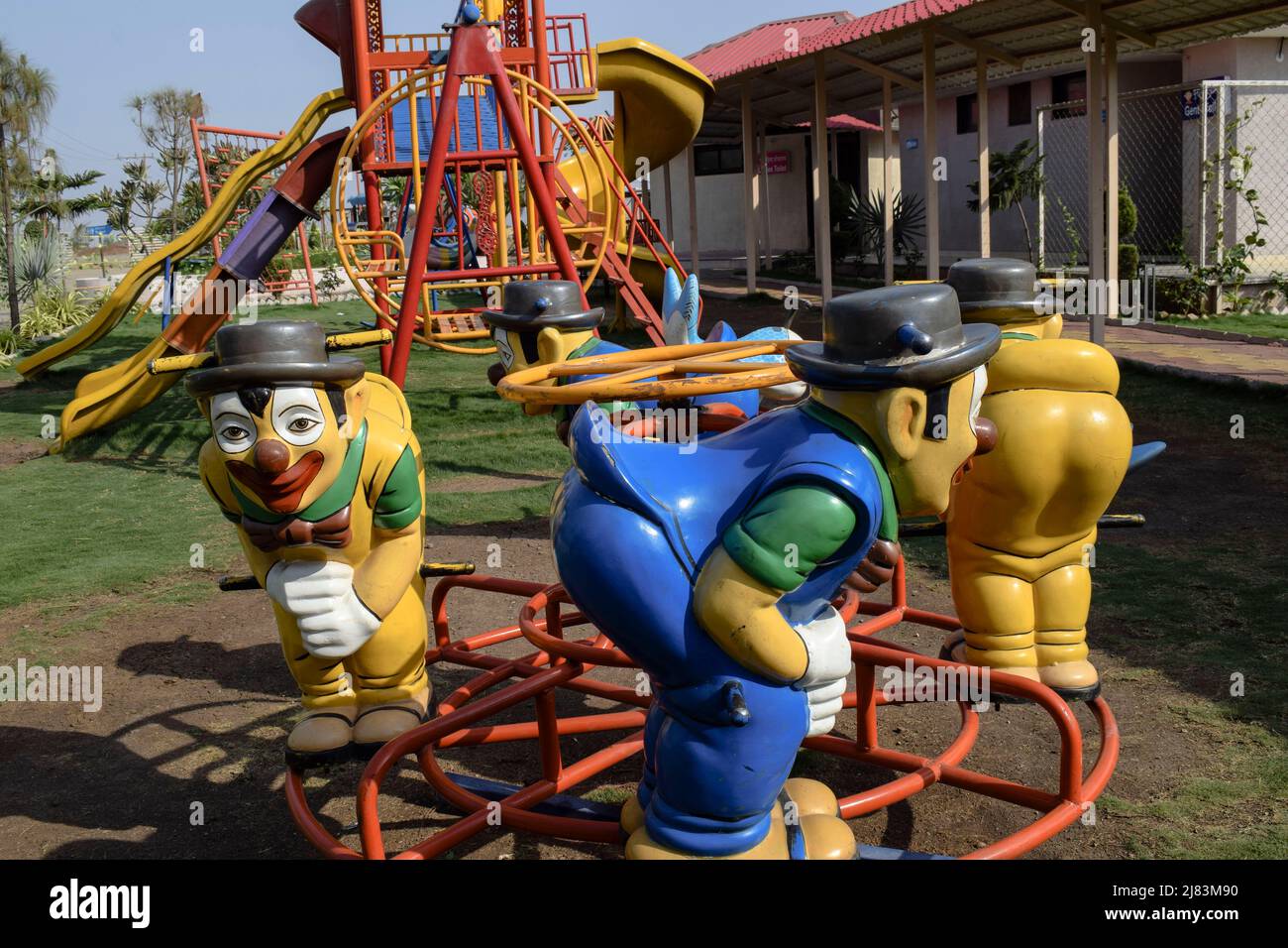 Bright colourful fun playground with slides and Clowns with hats ...