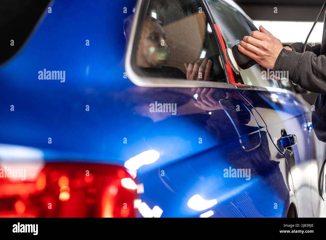 Auto mechanic worker polishing car at an automobile repair and renew ...