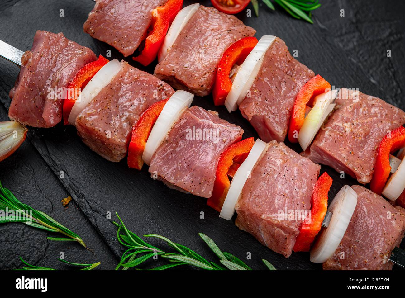 raw kebab with vegetables. On a black stone background Stock Photo - Alamy