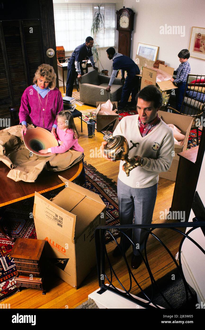 1980s FAMILY AND MOVING MEN UNPACKING IN NEW HOME MOVING RELOCATING ...