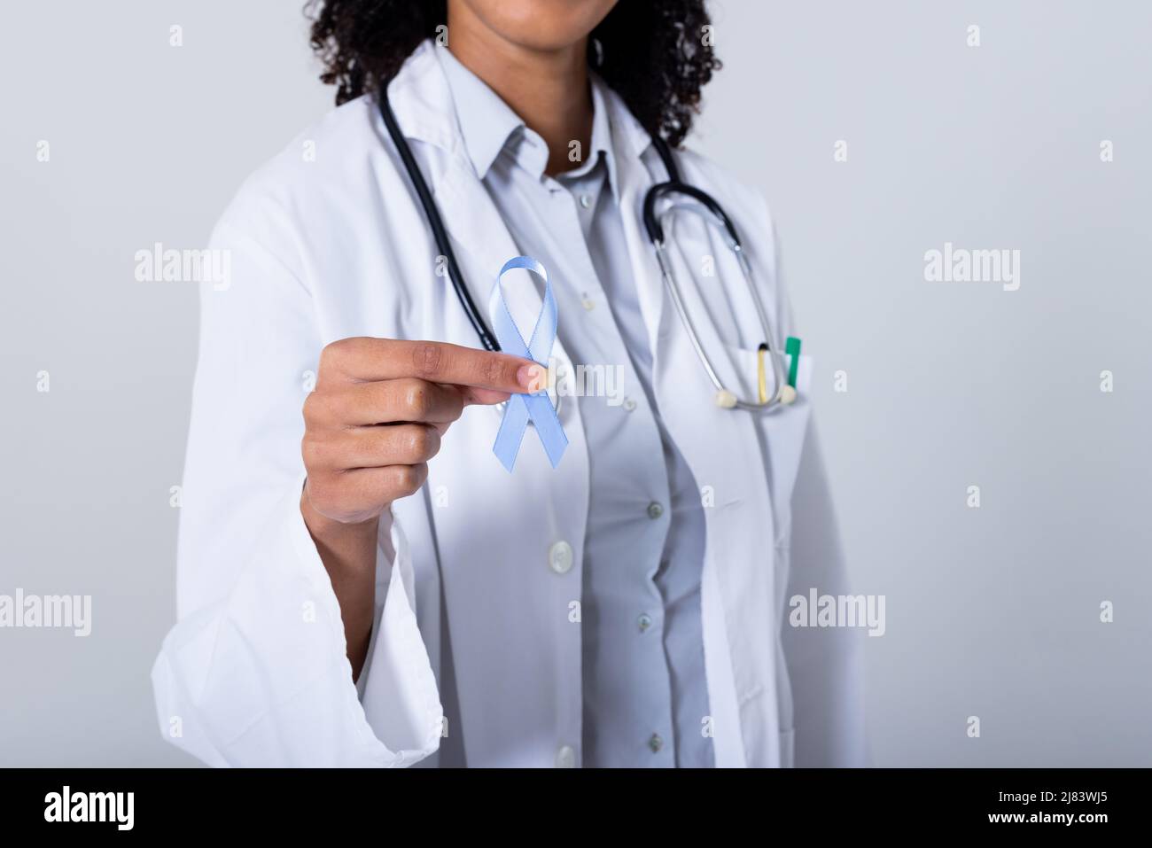 Midsection of african american mid adult female doctor holding blue ...