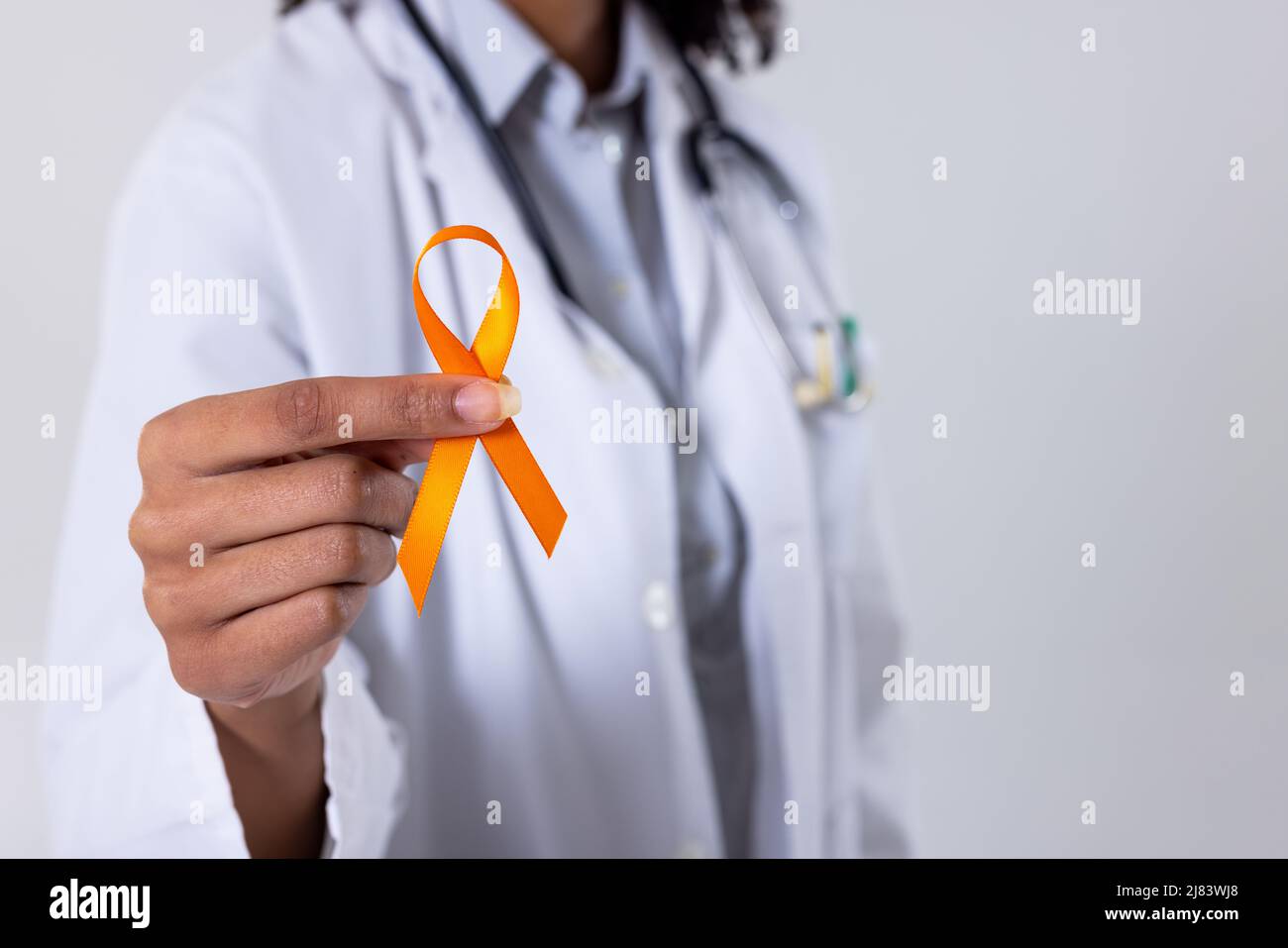 Midsection of african american mid adult female doctor with yellow ...