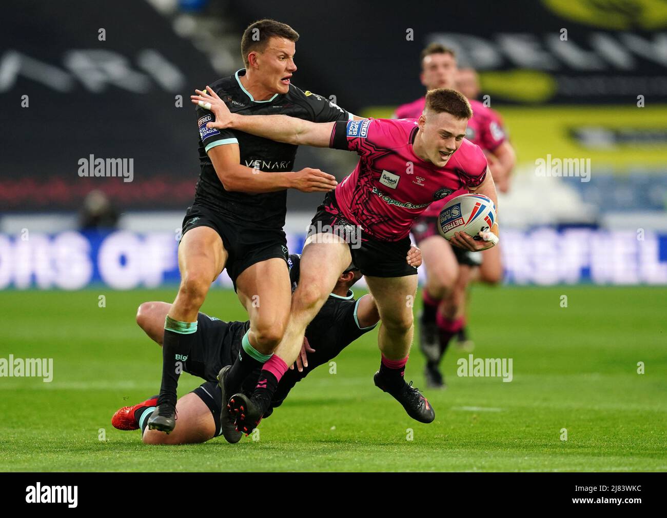 Wigan Warriors' Sam Halsall tackled by Huddersfield Giants' Louis ...