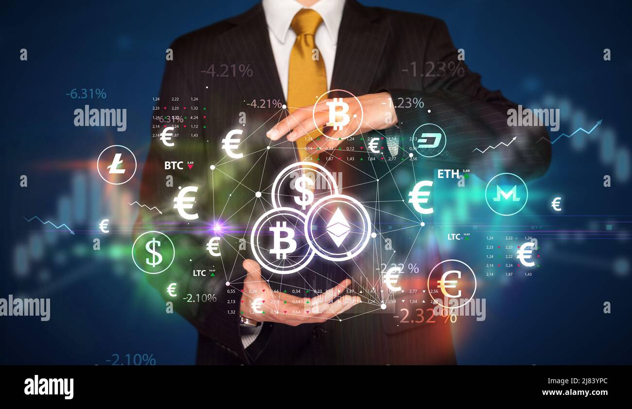 Businessman holding currency symbols concept Stock Photo - Alamy