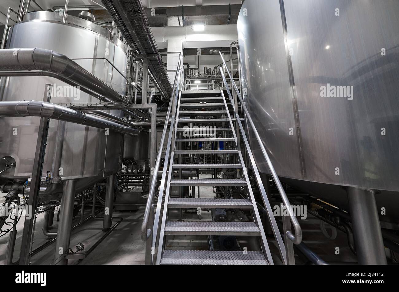 Metal steps near huge tanks for fermented milk products Stock Photo - Alamy