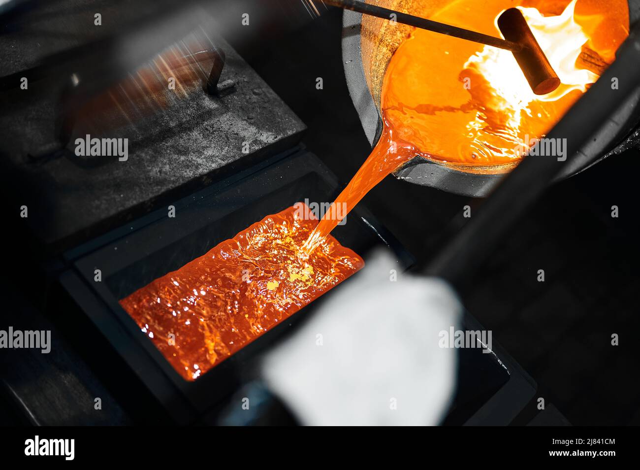 Pouring liquid silver into casting form with metal tool Stock Photo - Alamy