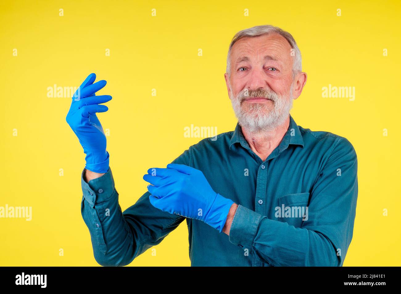 Portrait of a man with towel and spray ready to clean windows in studio ...