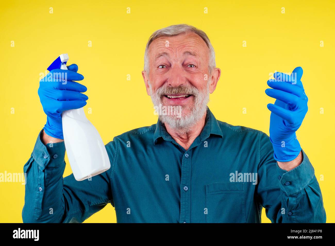 Portrait of a man with towel and spray ready to clean windows in studio ...