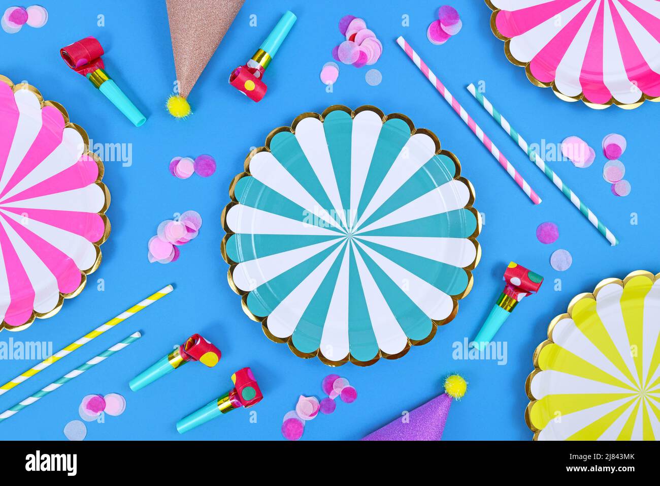 Party flat lay with paper plates, drinking straws and confetti on blue ...