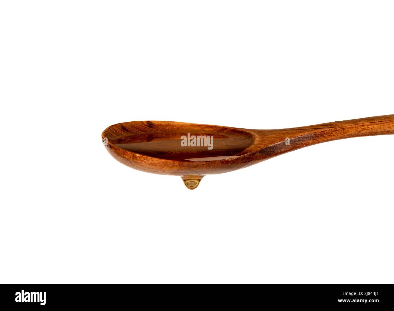 Wooden spoon with sunflower oil and a drop of oil from the bottom of ...