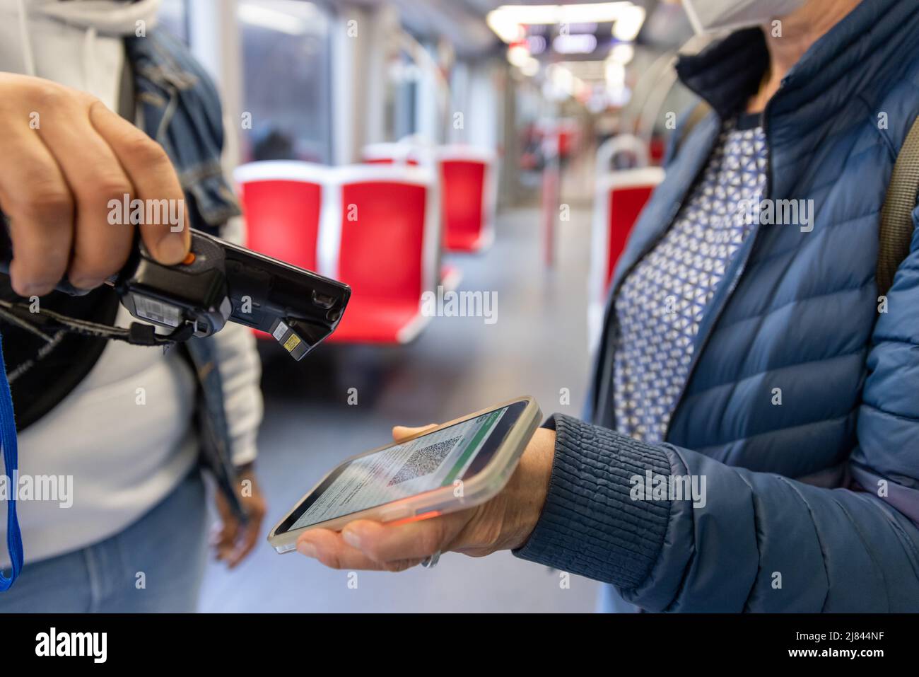 Nuremberg, Germany. 05th May, 2022. ILLUSTRATION - A ticket inspector (l) checks the electronic ...