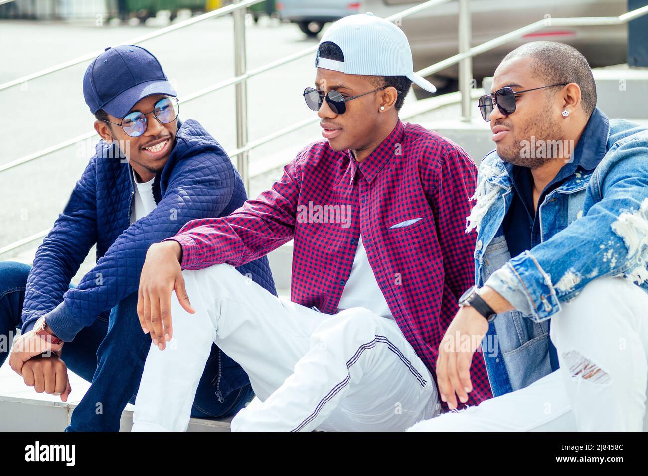 Friends talking together on a bench in the city Stock Photo - Alamy