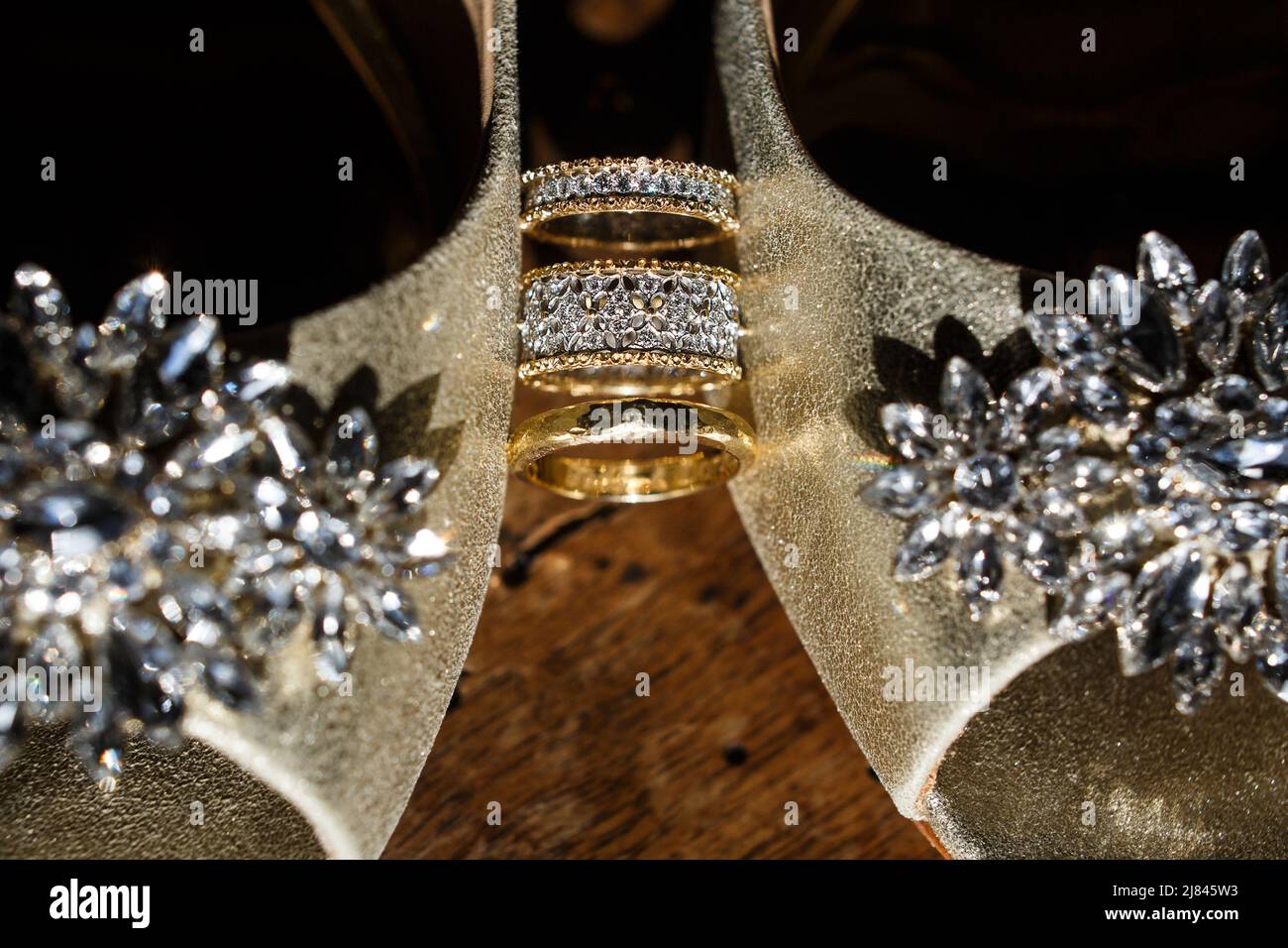 Wedding ring between wedding shoes and highlights Stock Photo - Alamy