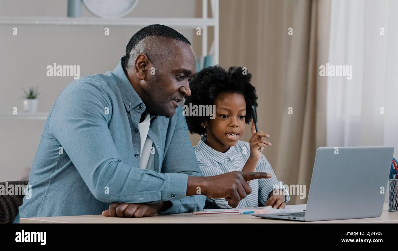 Caring african american father helping little daughter schoolgirl do ...