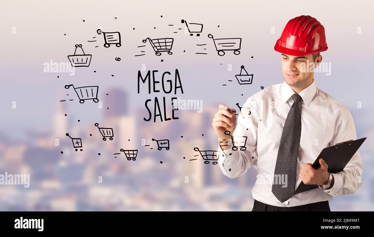 Young businessman with helmet drawing sale sign Stock Photo - Alamy