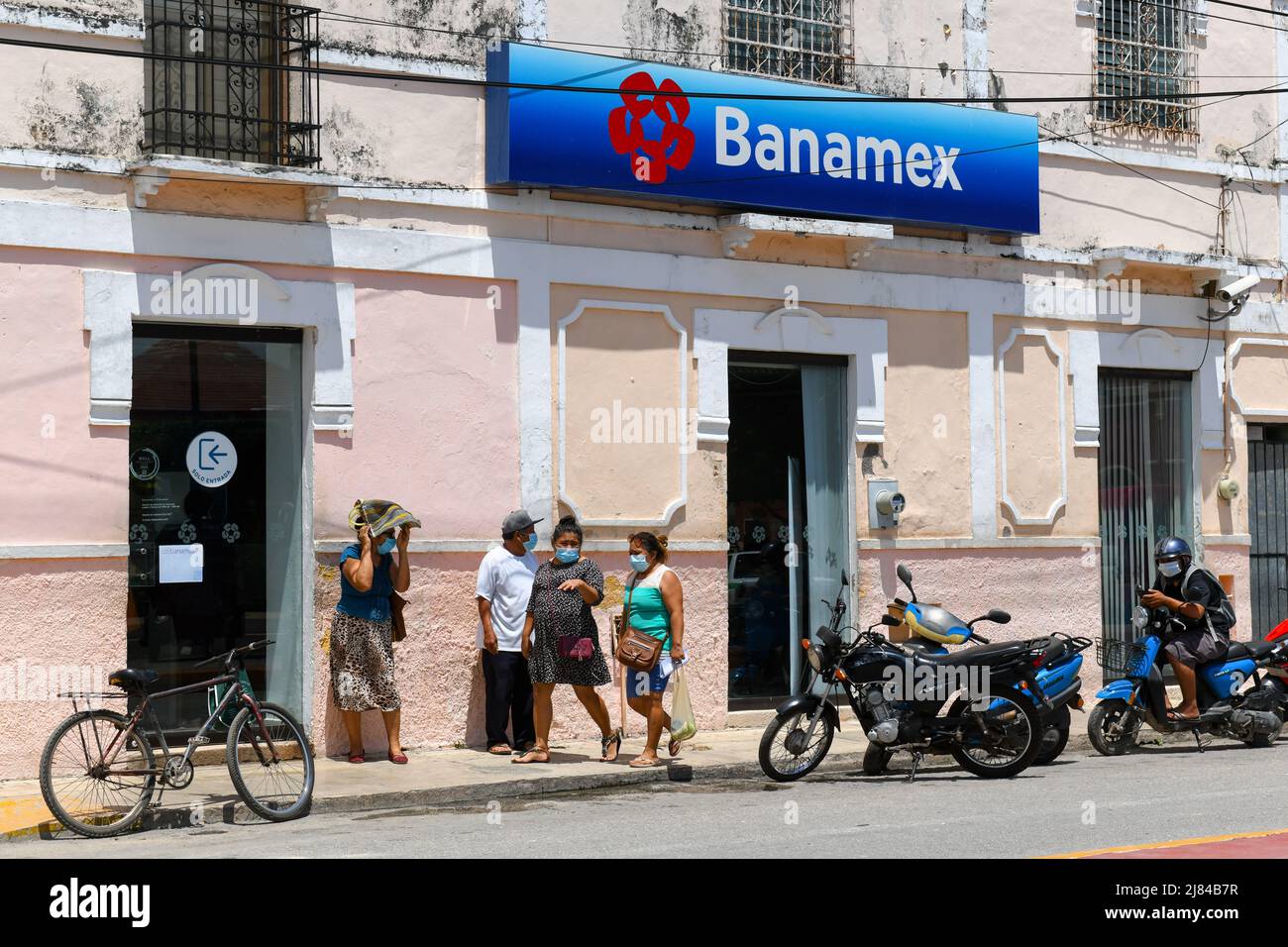 People waiting under the heat in front of Banamex Mexican bank in the ...