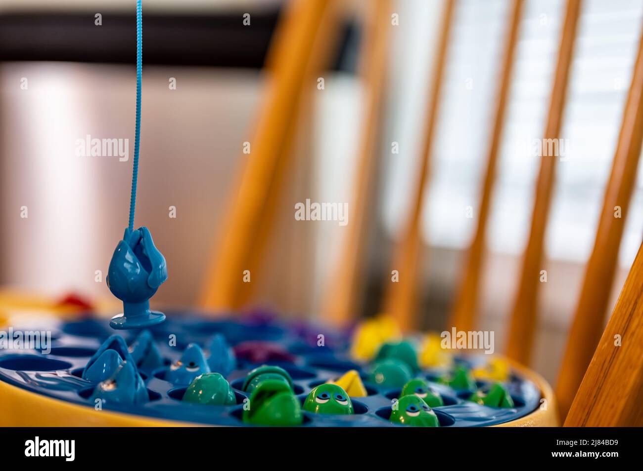 Children's game of using a miniature pole and line lowered into open ...