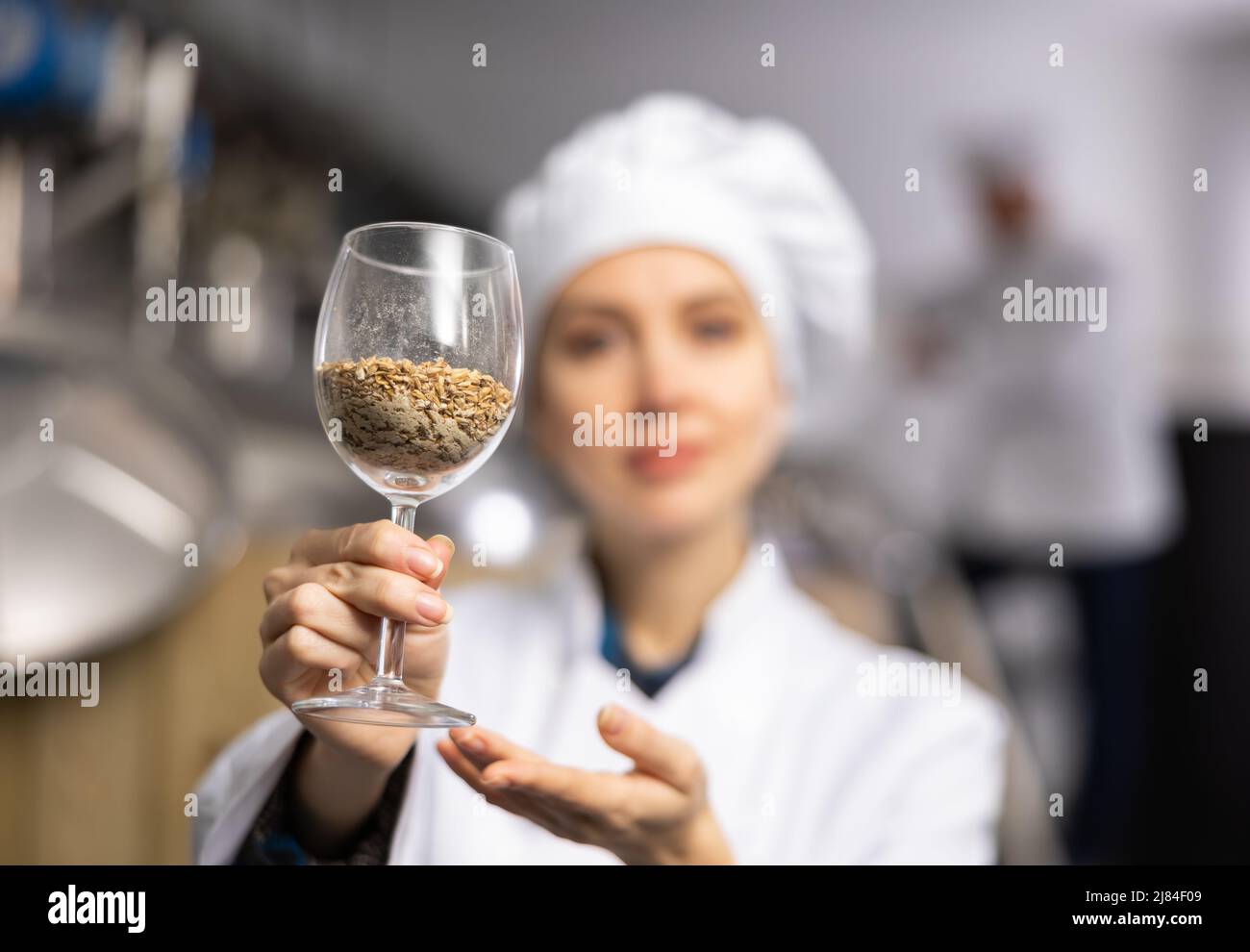 Woman brewer showing malted grain for craft beer production Stock Photo ...
