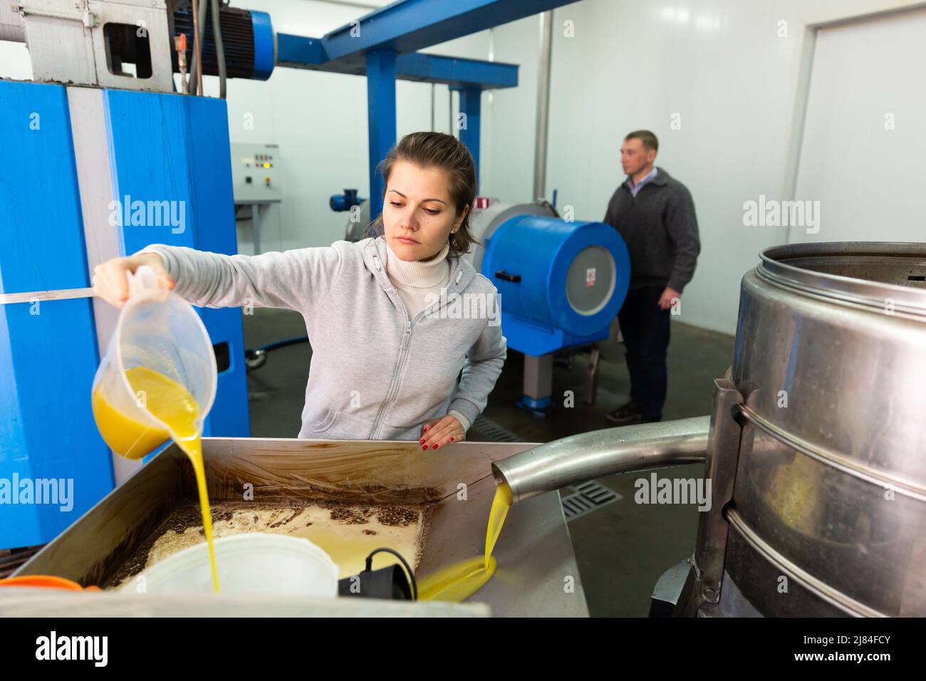 Woman inspecting oil decanting Stock Photo - Alamy