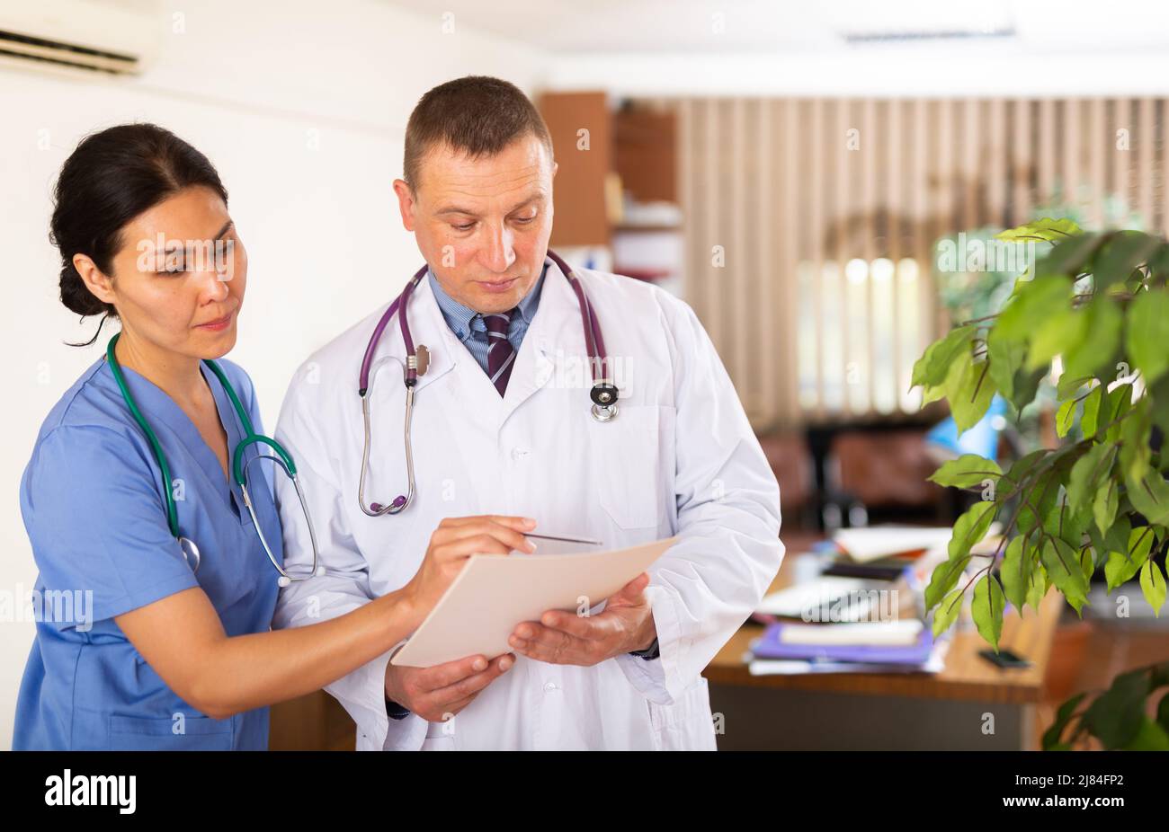 Two doctors checking patient papers in clinic Stock Photo - Alamy