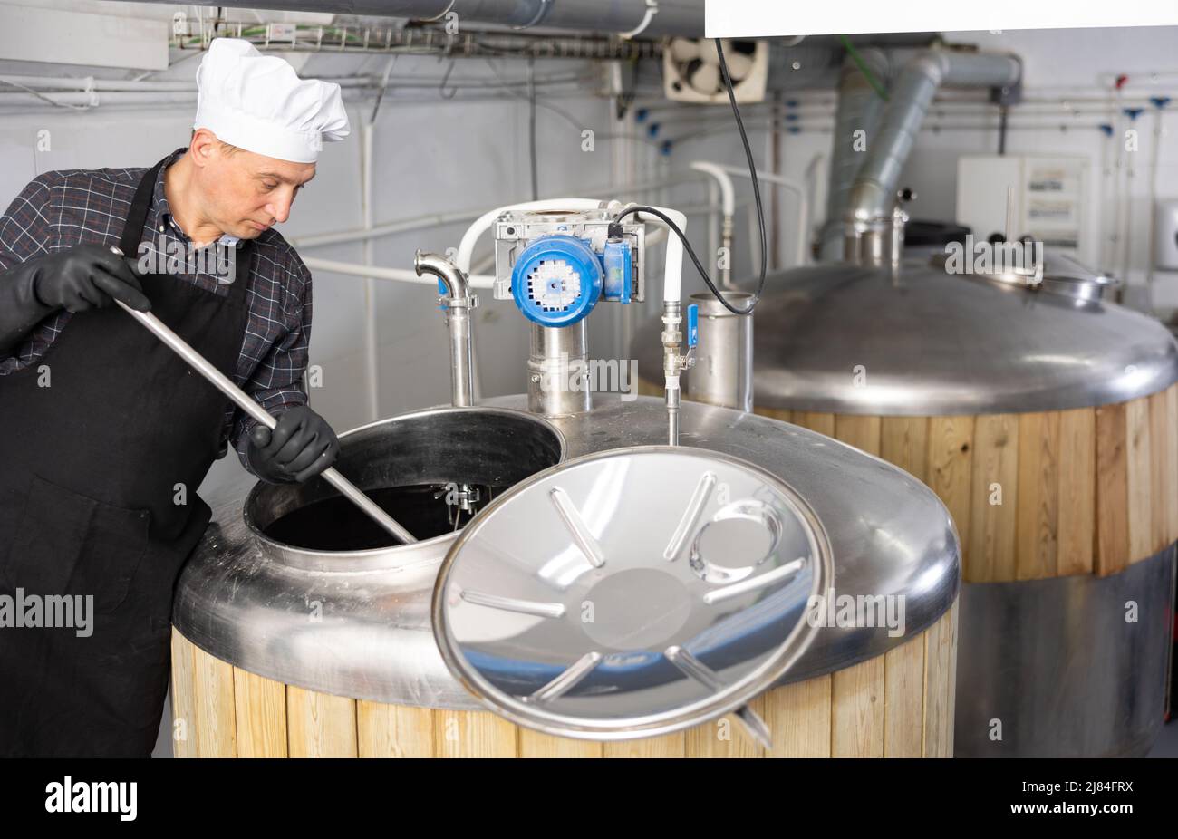 Brewmaster mixing beer components in tank Stock Photo - Alamy