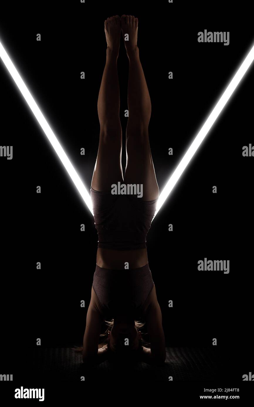 Fit woman practicing yoga poses. Silhouette girl doing exercise in ...
