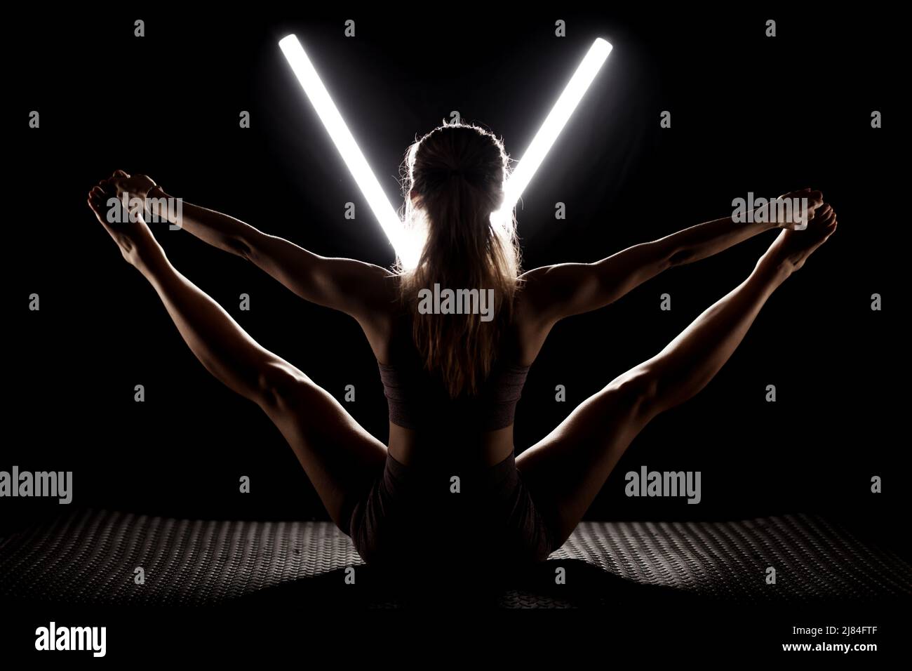 Fit woman practicing yoga poses. Silhouette girl doing exercise in ...
