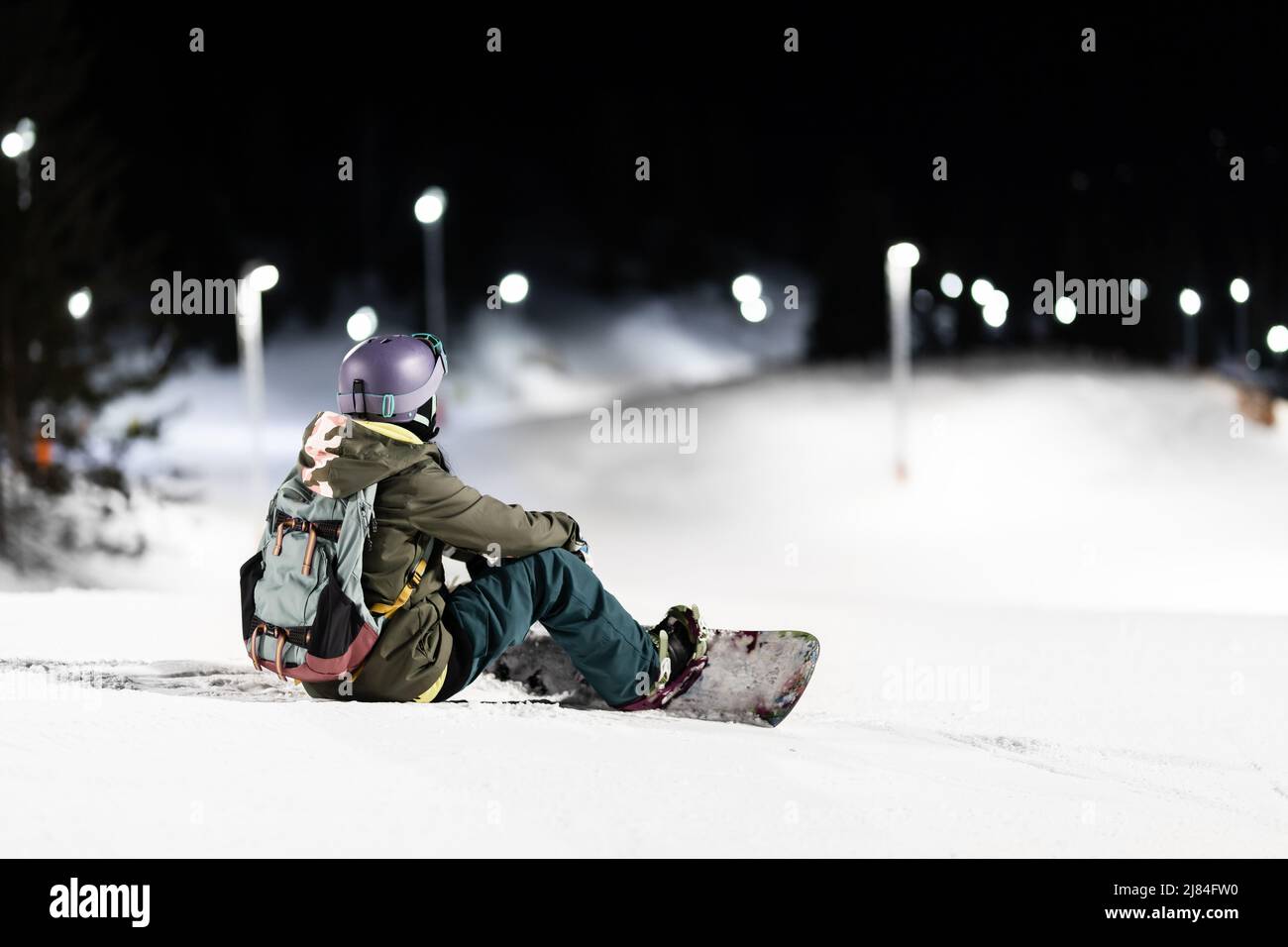Snowboarder girl posing on slopes. Night skiing in winter resort Stock ...