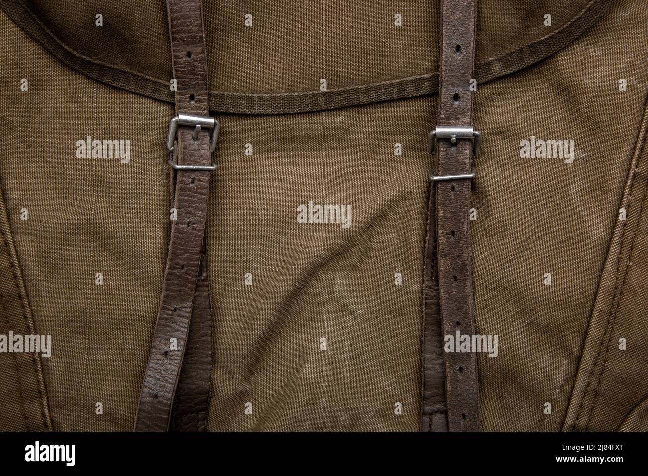Close-up texture of a canvas fabric backpack. Leather straps and metal ...