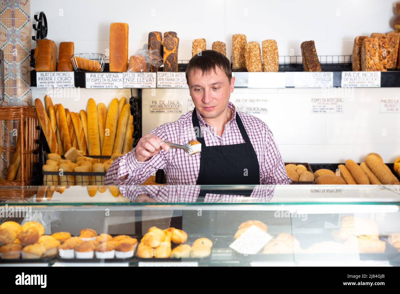 Baker working behind counter in bakery Stock Photo - Alamy