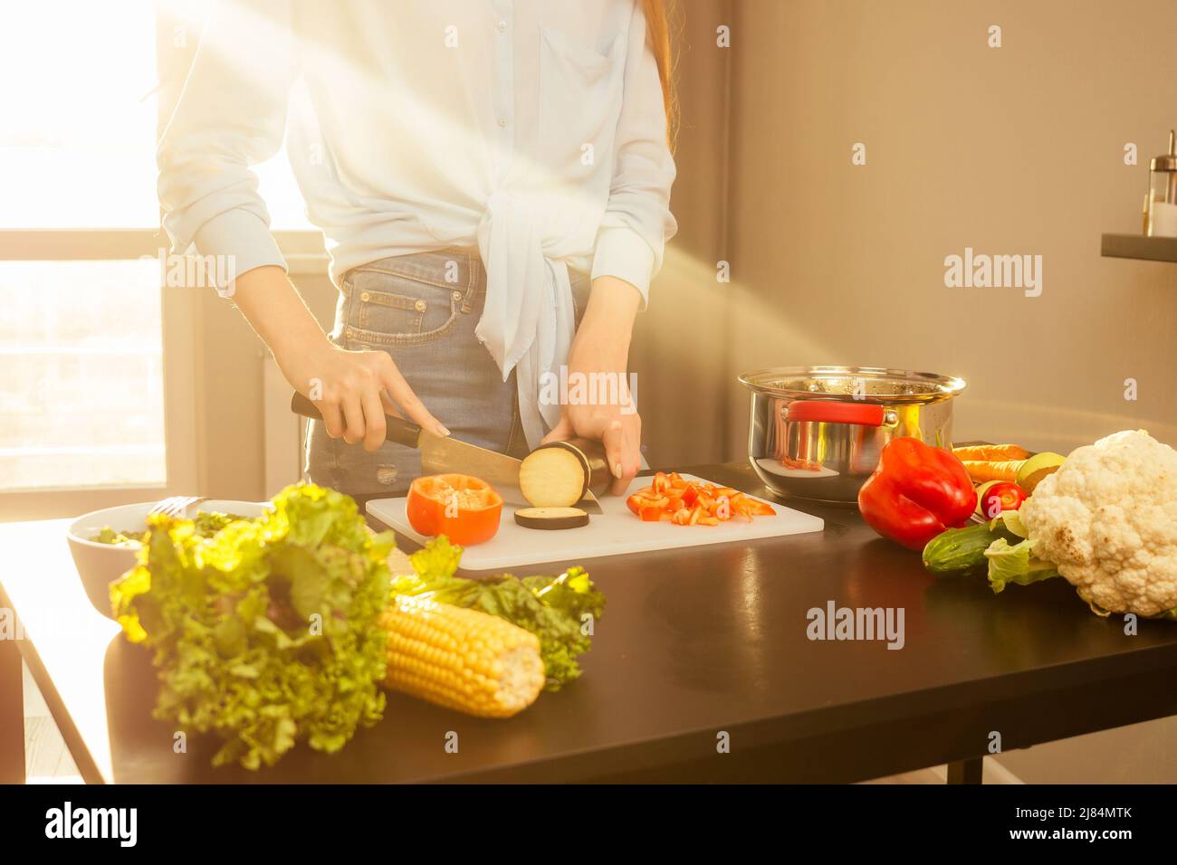 happy redhaired ginger woman cooking in evening sun lights sunset ...