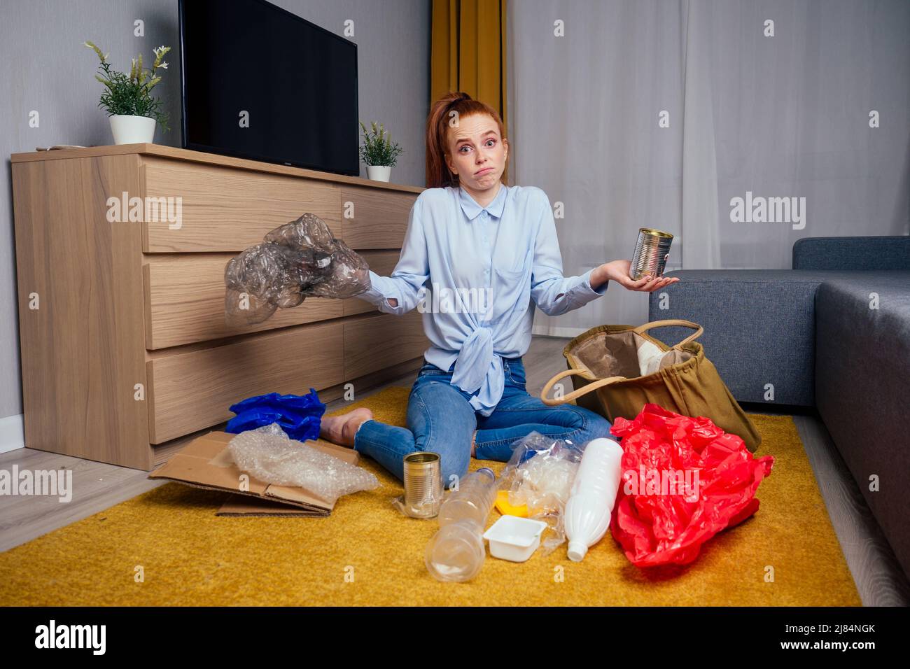 unhappy redhaired ginger girl sorting waste:bottle,paper and plastic ...