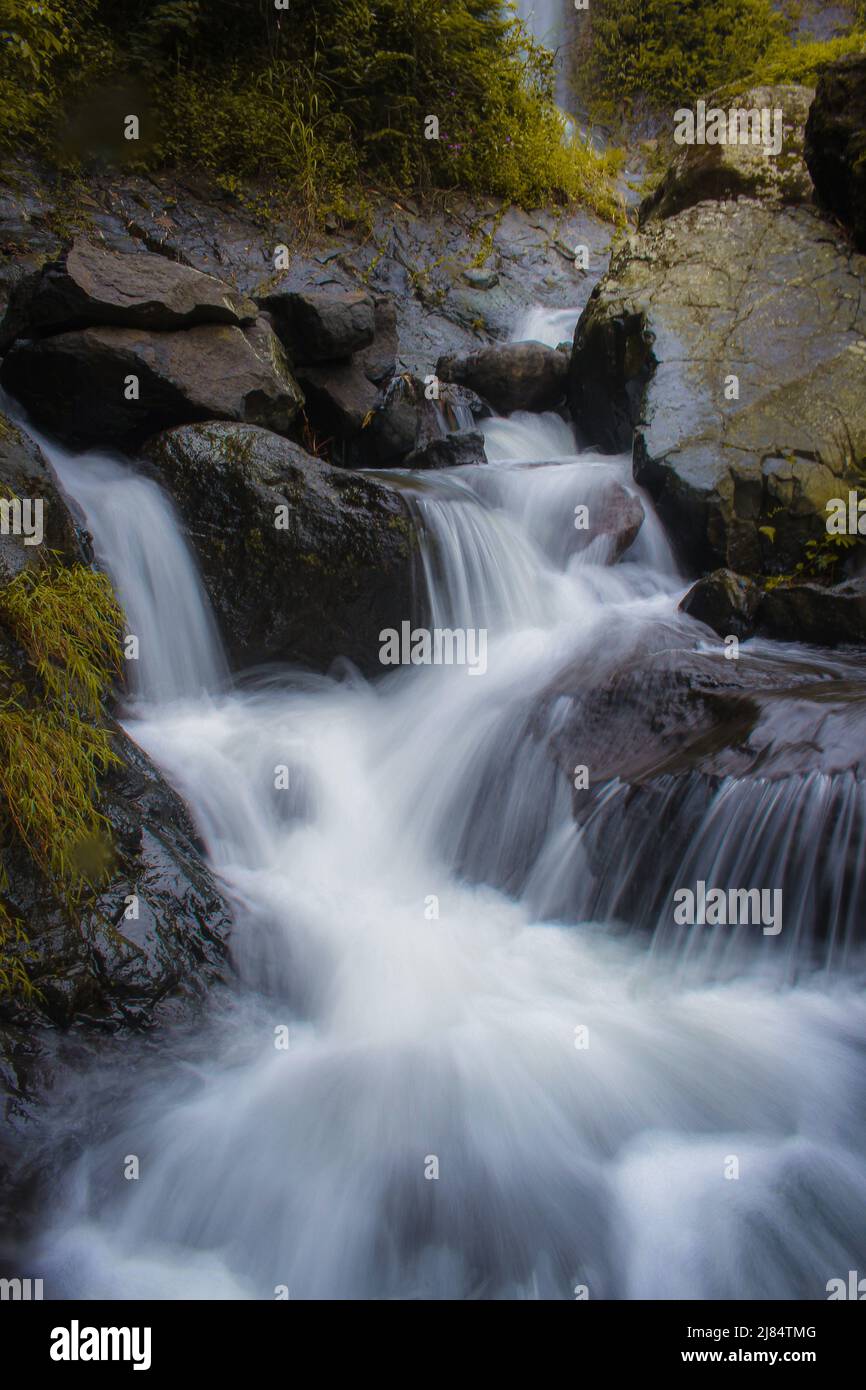 The river of the waterfall is quite heavy with rocks creating a ...