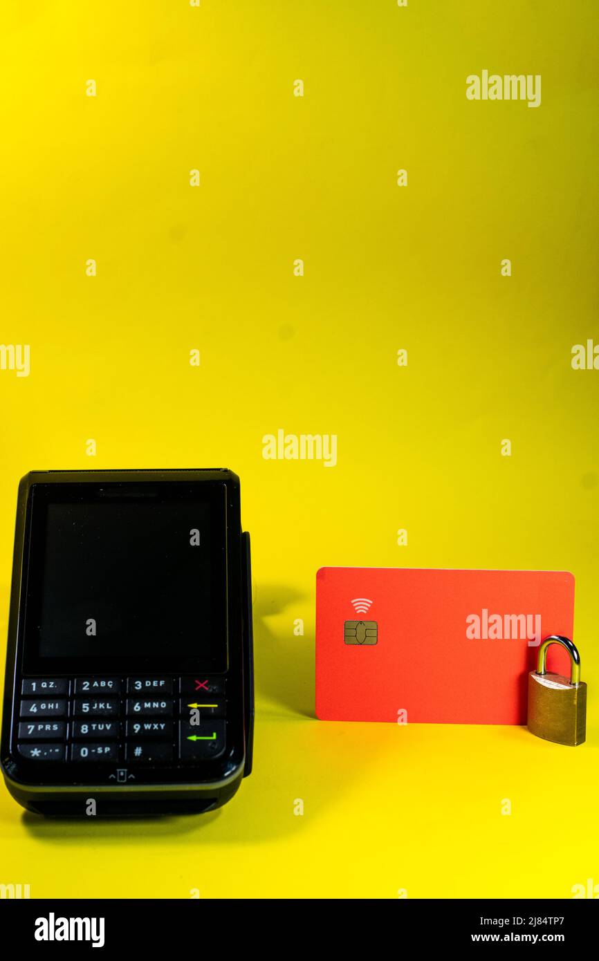 A card terminal in a yellow background with a padlock and a card Stock ...