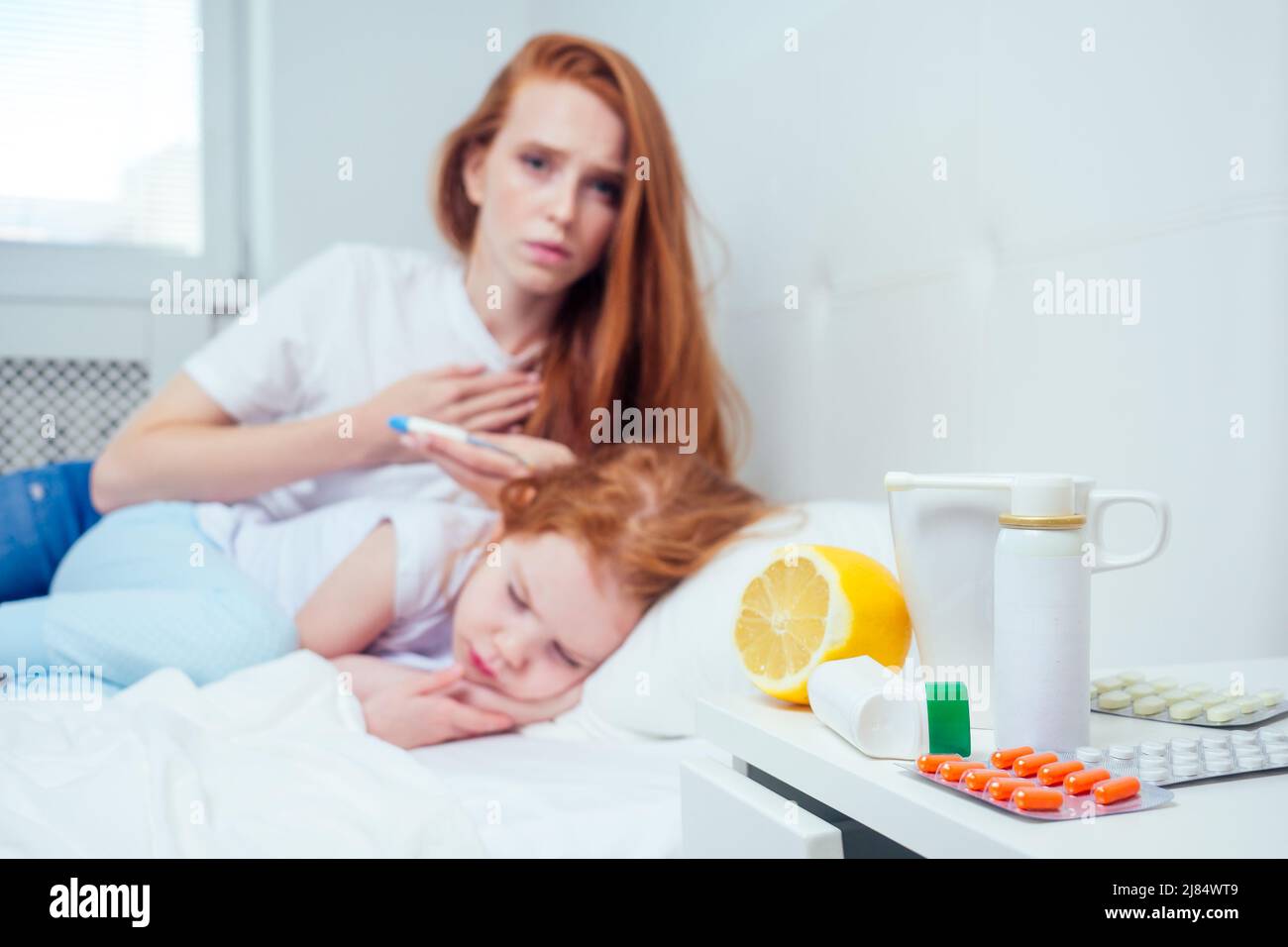 redhaired ginger worried woman checking temperature of her sick little ...