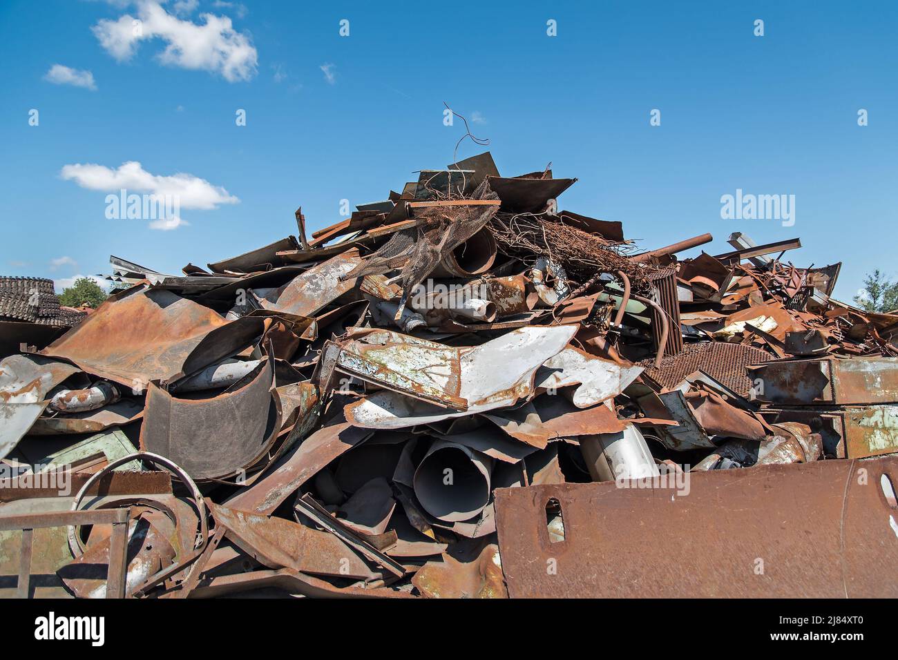 A pile of rusty scrap iron against the blue sky Stock Photo - Alamy