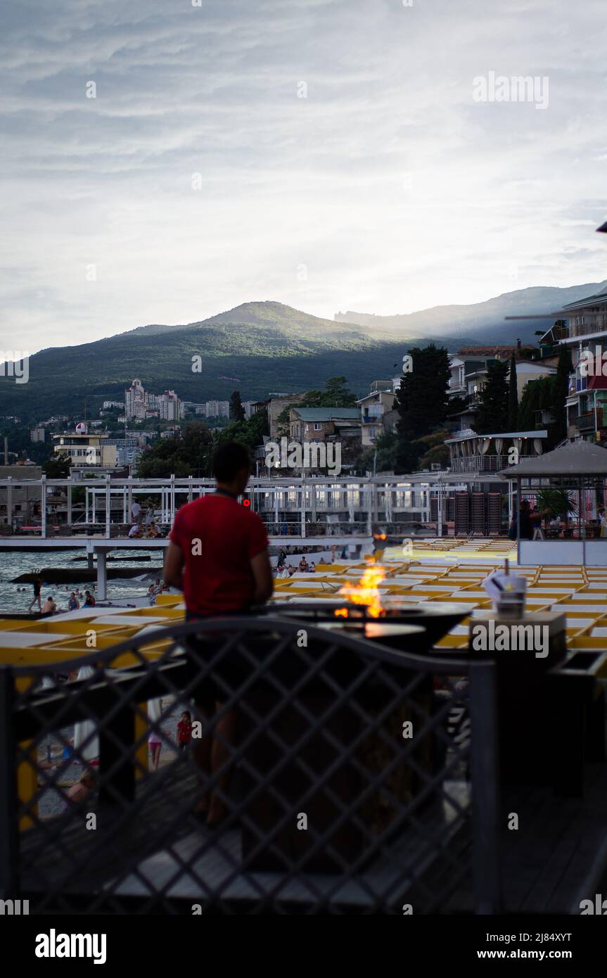 A man cooks on a fire on the beach. An appliance for cooking in a ...