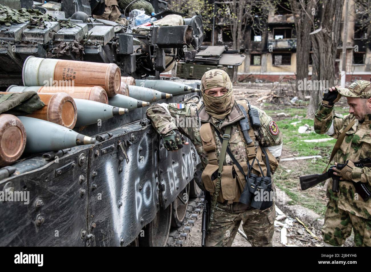 A Russian soldier leans on a Russian T-80 tank lined with shells in ...