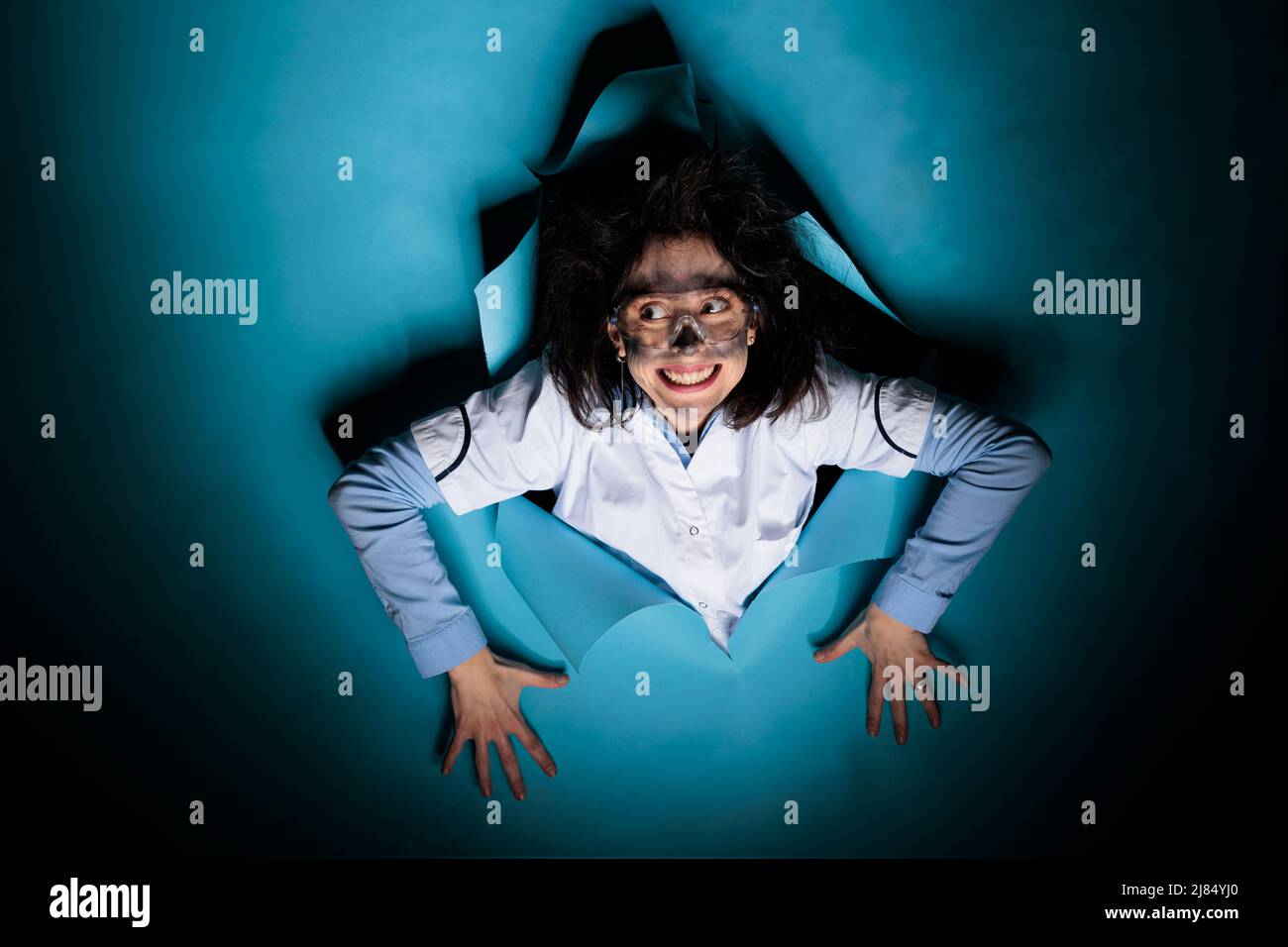 Lunatic chemist with messy hair and dirty face grinning dreadful after ...