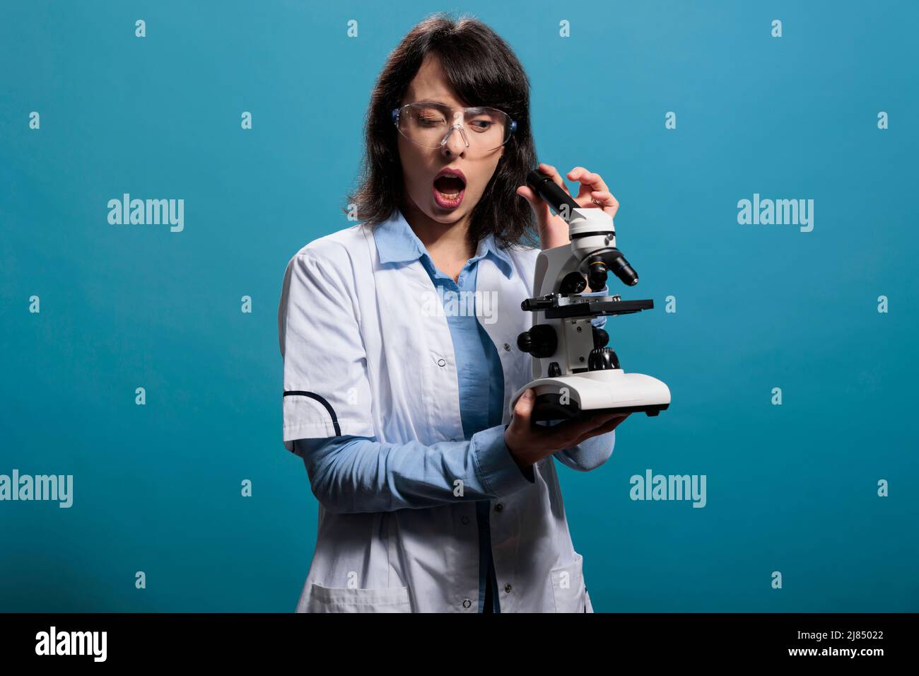 Chemistry researcher using microscope magnifying hi-res stock ...
