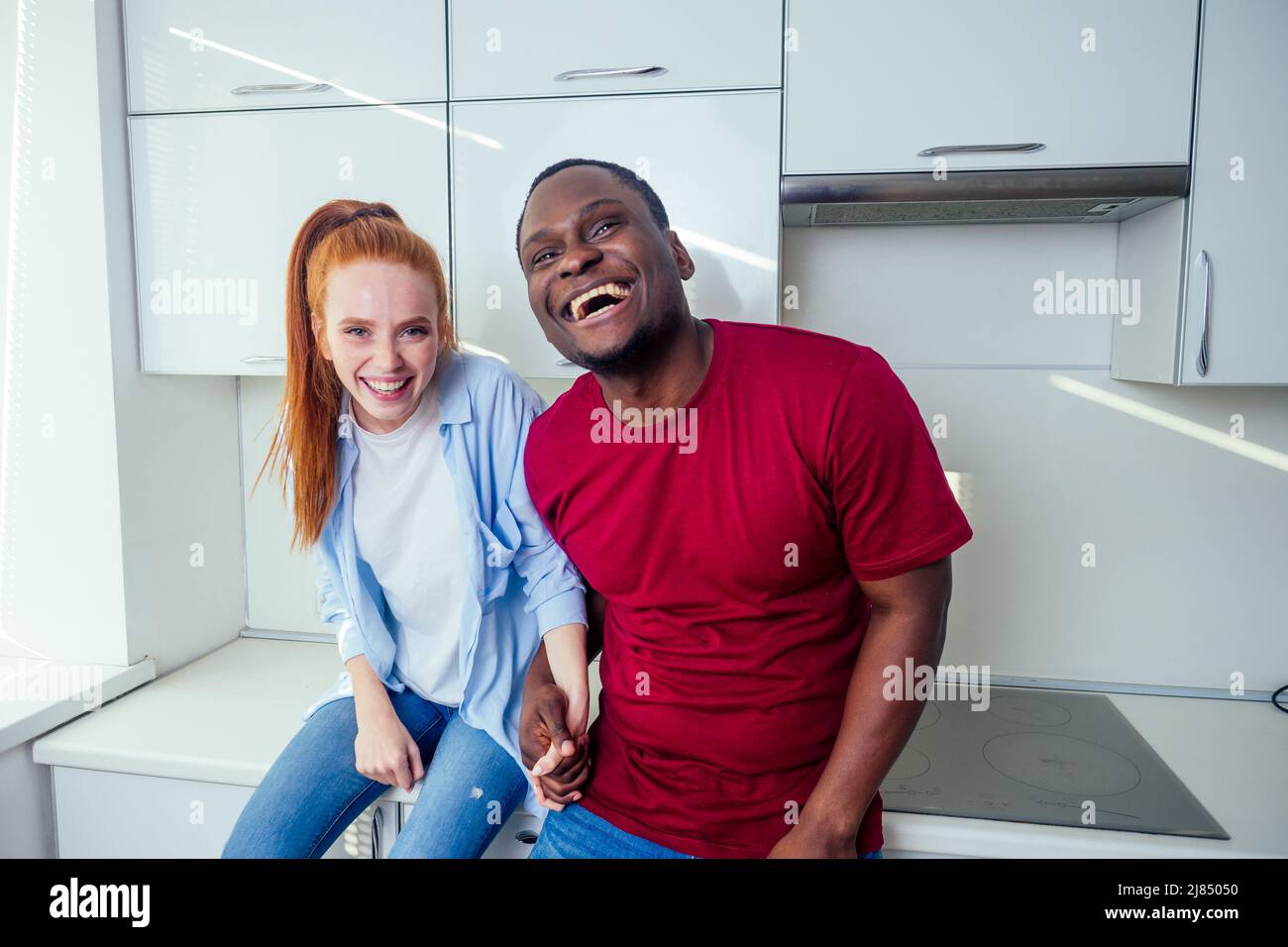 african american man and redhaired ginger woman dancing at kichen and ...