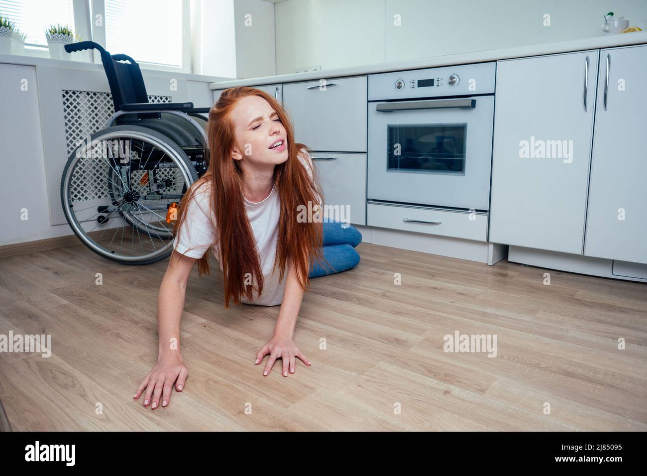 redhaired ginger woman falling down and crawling for help in kitchen ...