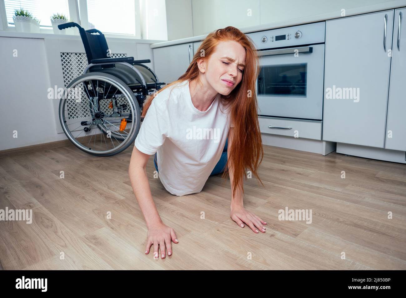 redhaired ginger woman falling down and crawling for help in kitchen ...