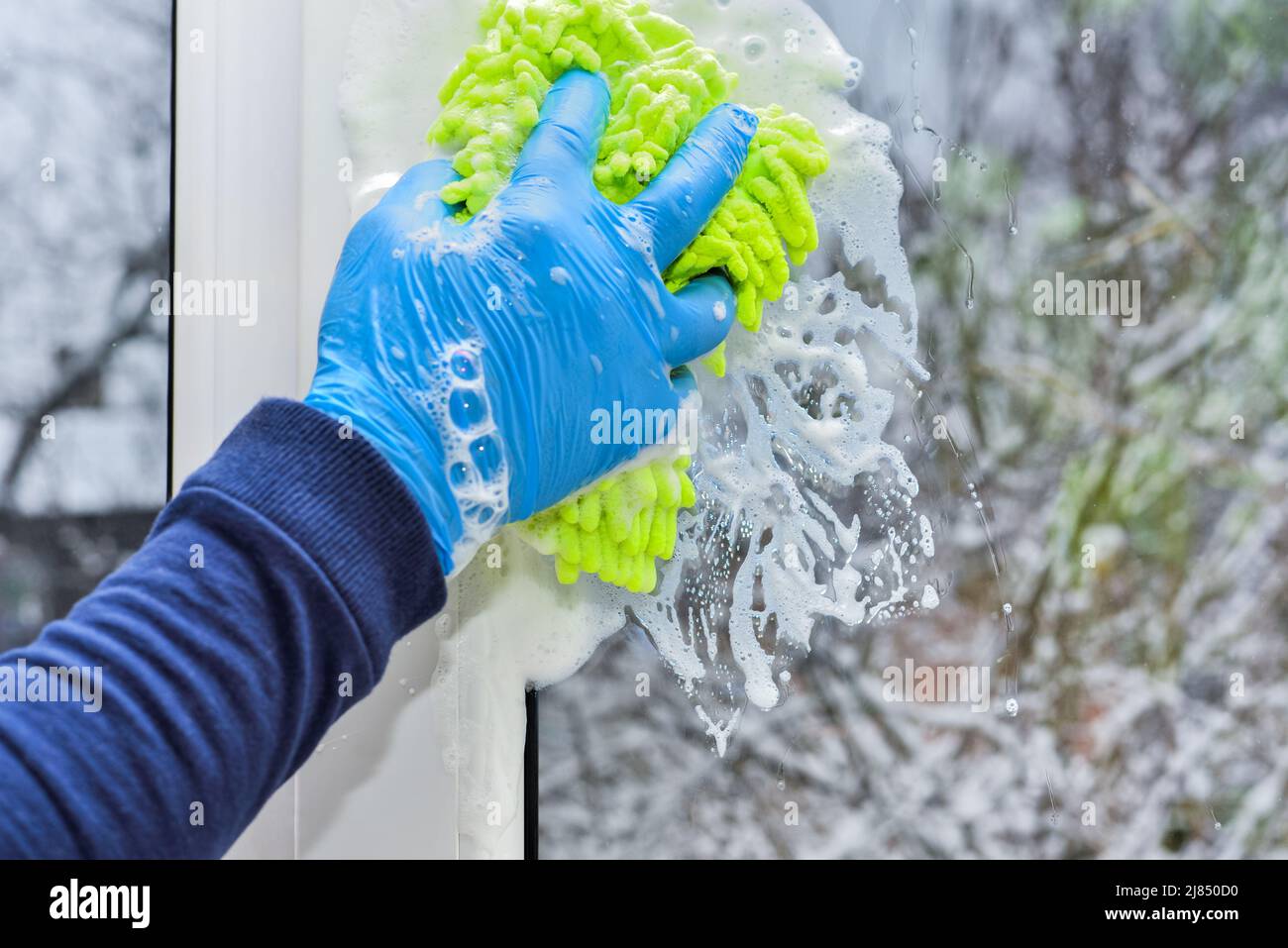 Sponge and foam on glass when cleaning and washing window. House ...