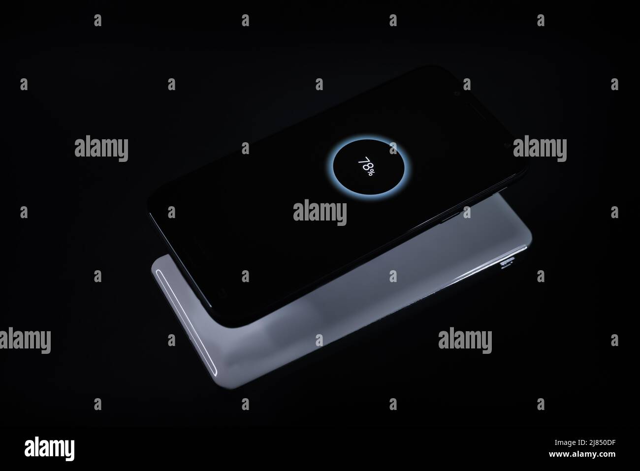 Smartphone screen while wireless charging from a charger on black ...