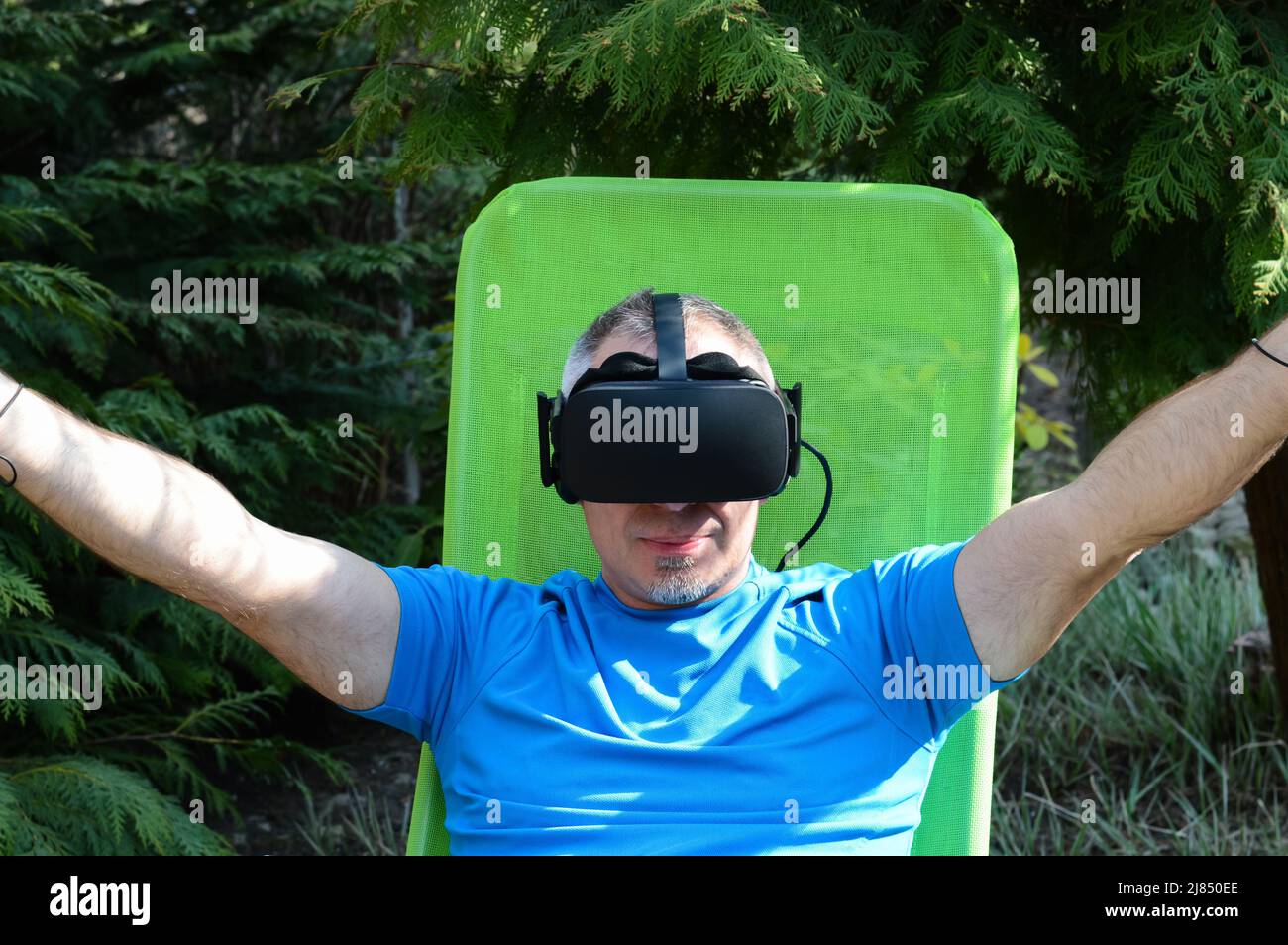 Happy man using a virtual reality headset enjoys the game and ...