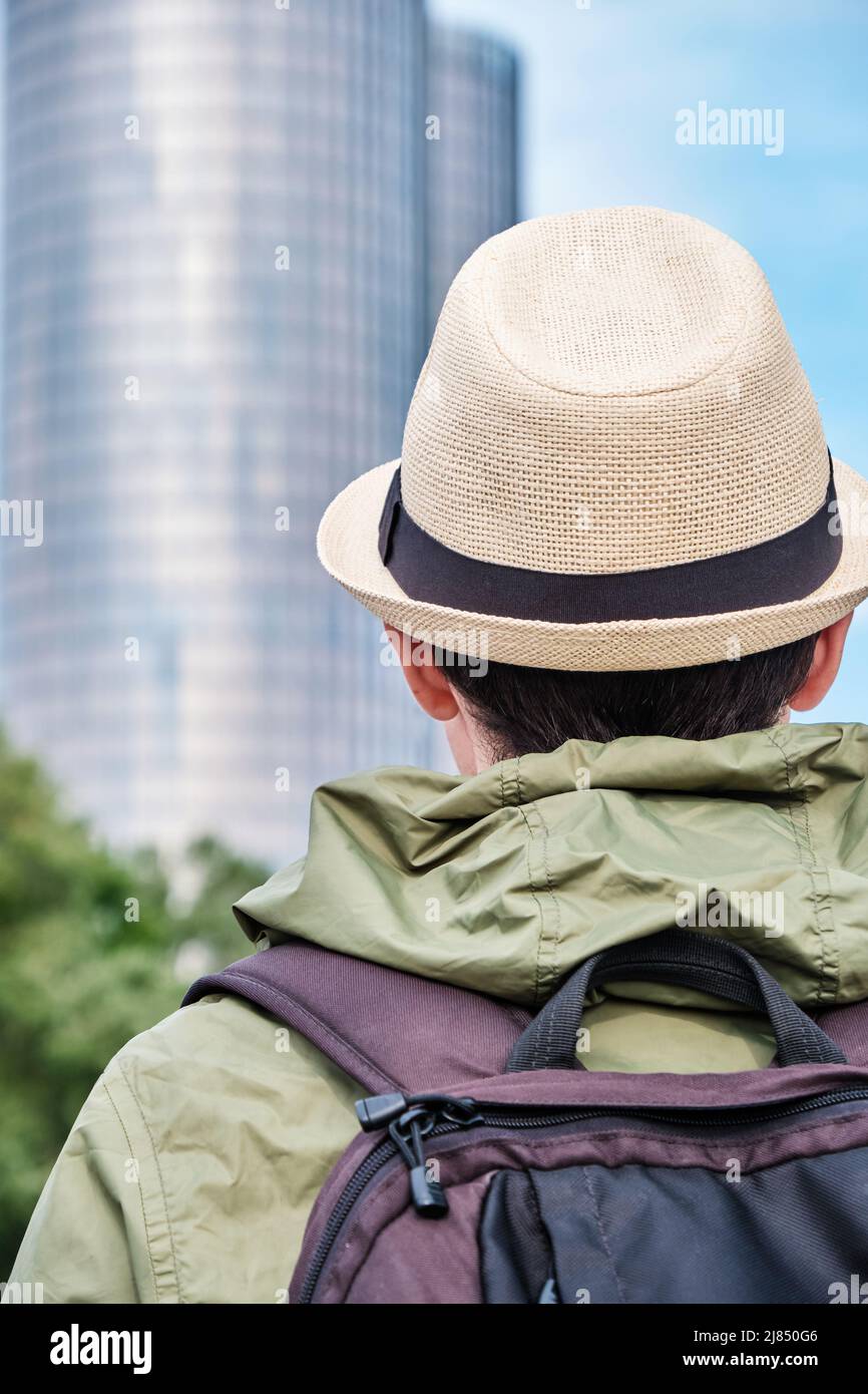 Back view of a man in a hat standing and thinks about work and career ...