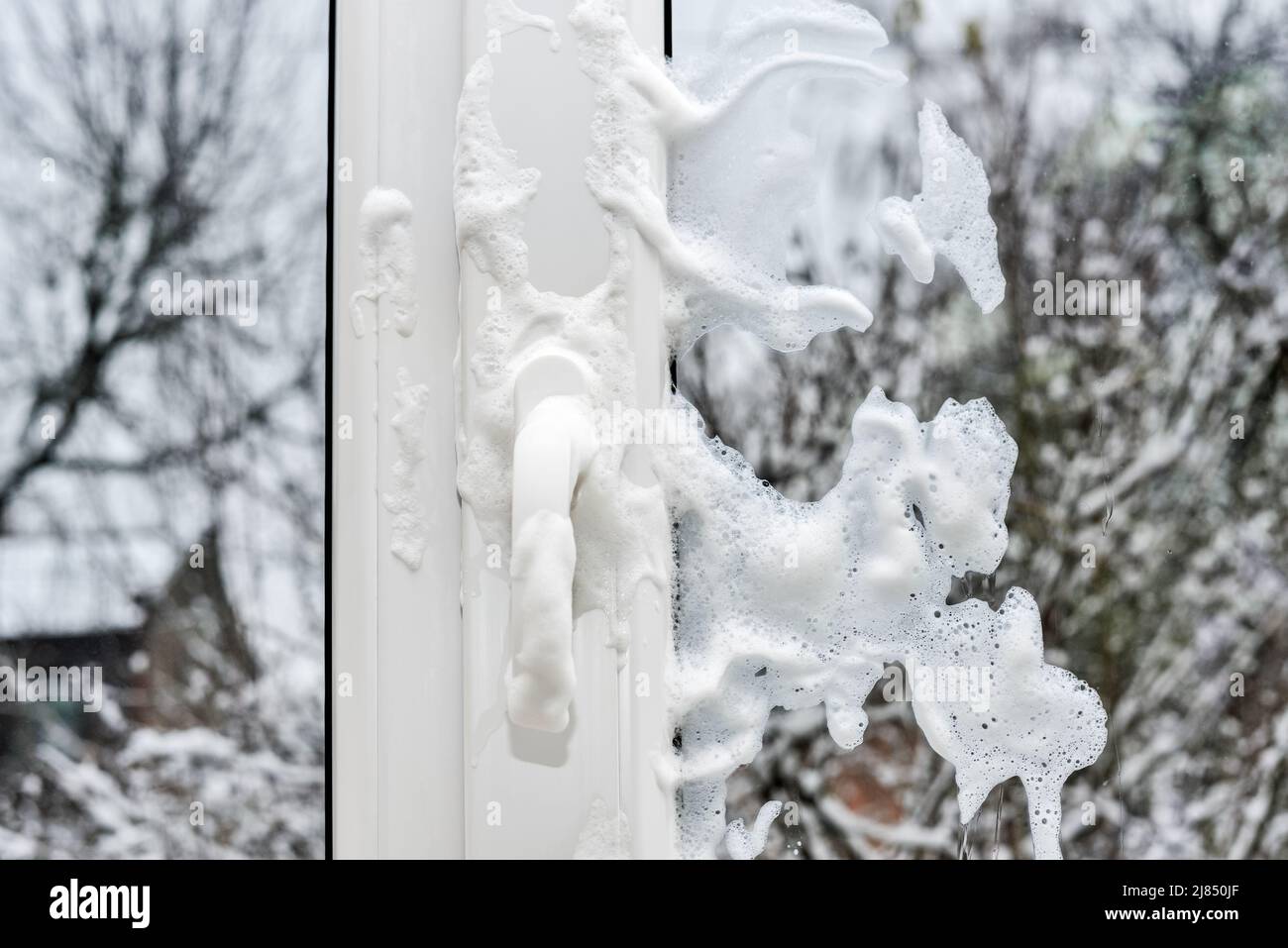 Foam on glass and plastic window frame during cleaning and washing ...